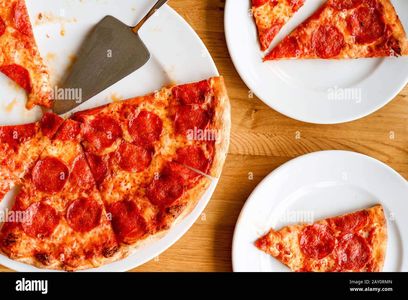 Pepperoni pizza slices on plates Stock Photo - Alamy