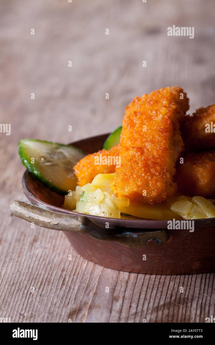 Fish fingers with potato salad Stock Photo - Alamy