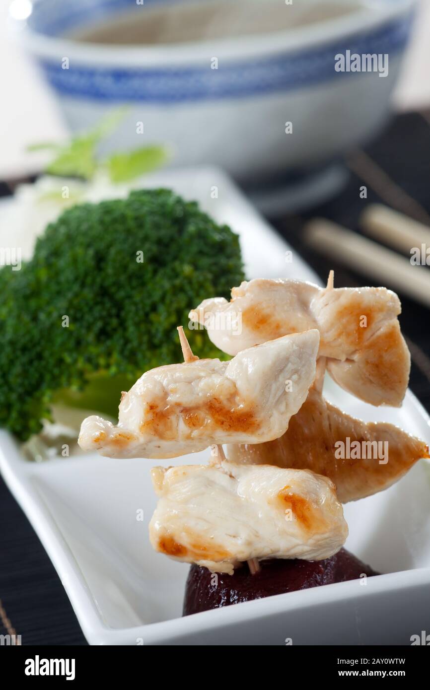 grilled chicken on a skewer with chopsticks Stock Photo - Alamy