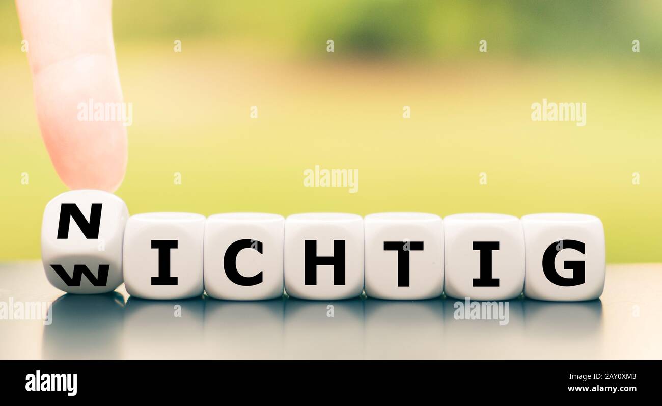 Hand turns dice and changes the German word "wichtig" ("important") to ...