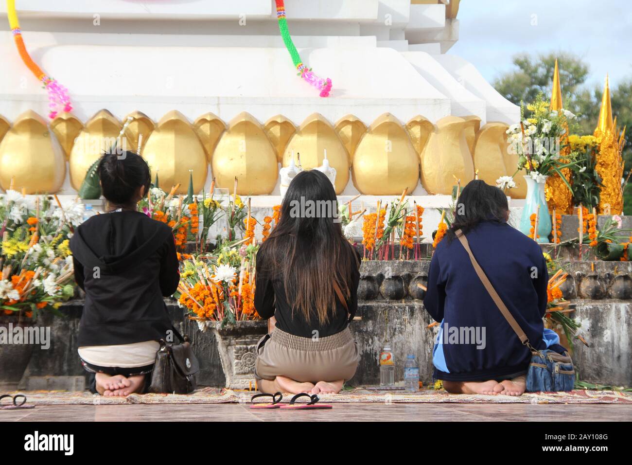People praying at the foot of the idol hi-res stock photography and ...
