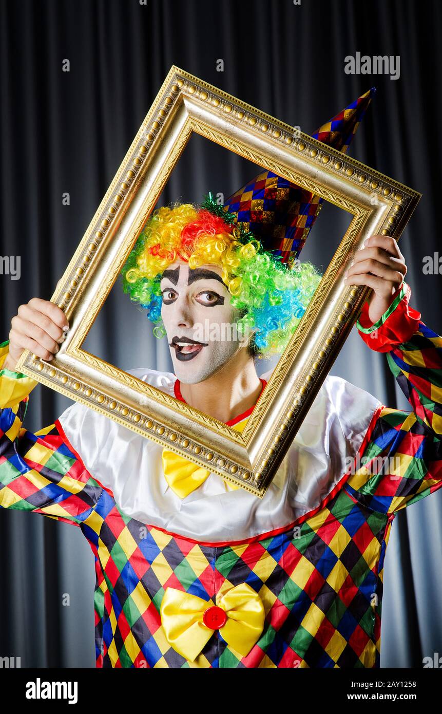 Clown with picture frames in studio Stock Photo - Alamy