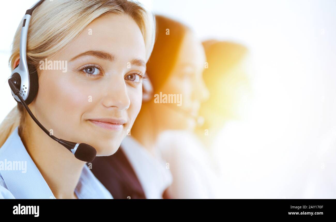 Group of diverse phone operators at work in sunny office. Handsome ...