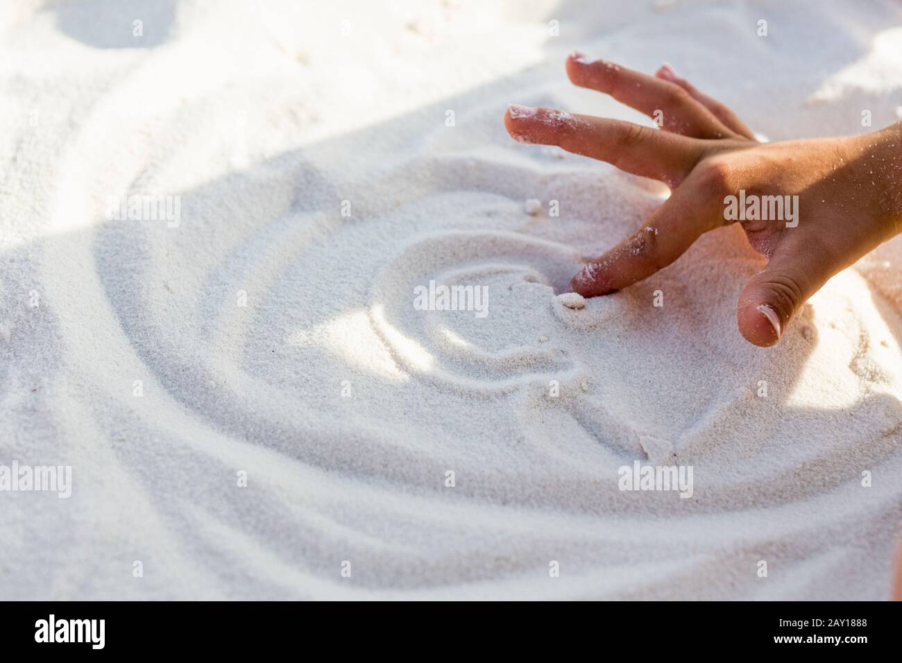 young boys hand making a design in sand Stock Photo - Alamy