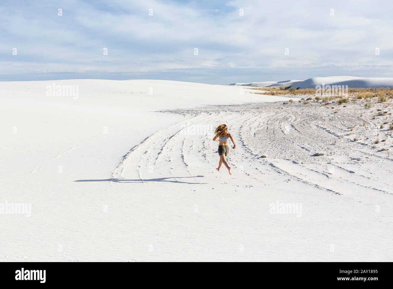 A teenage girl running in the sand, White Sands Nat'l Monument, NM ...