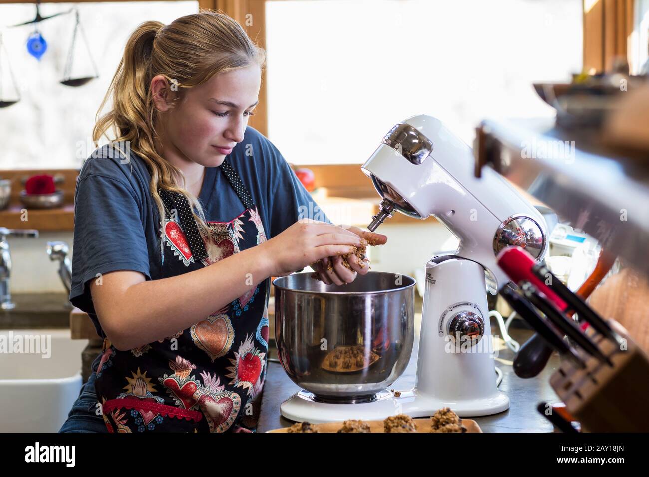 Thirteen year old teenage girl using mixer in the kitchen Stock Photo ...