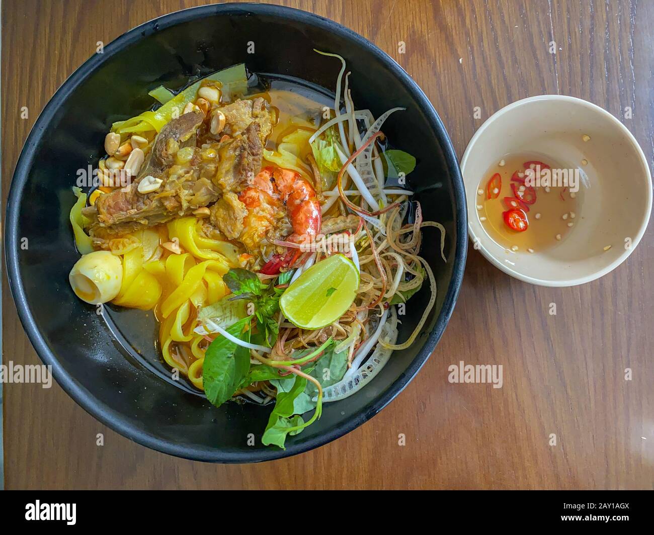 Vietnamese cuisine- rice noodles Mi Quang served with fish sauce Stock ...