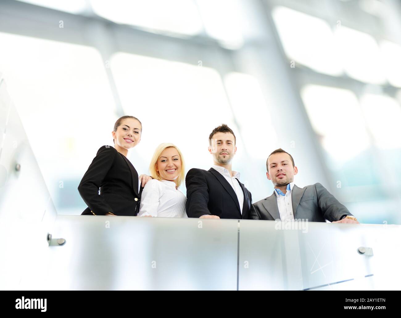 Successful business people on railing Stock Photo - Alamy