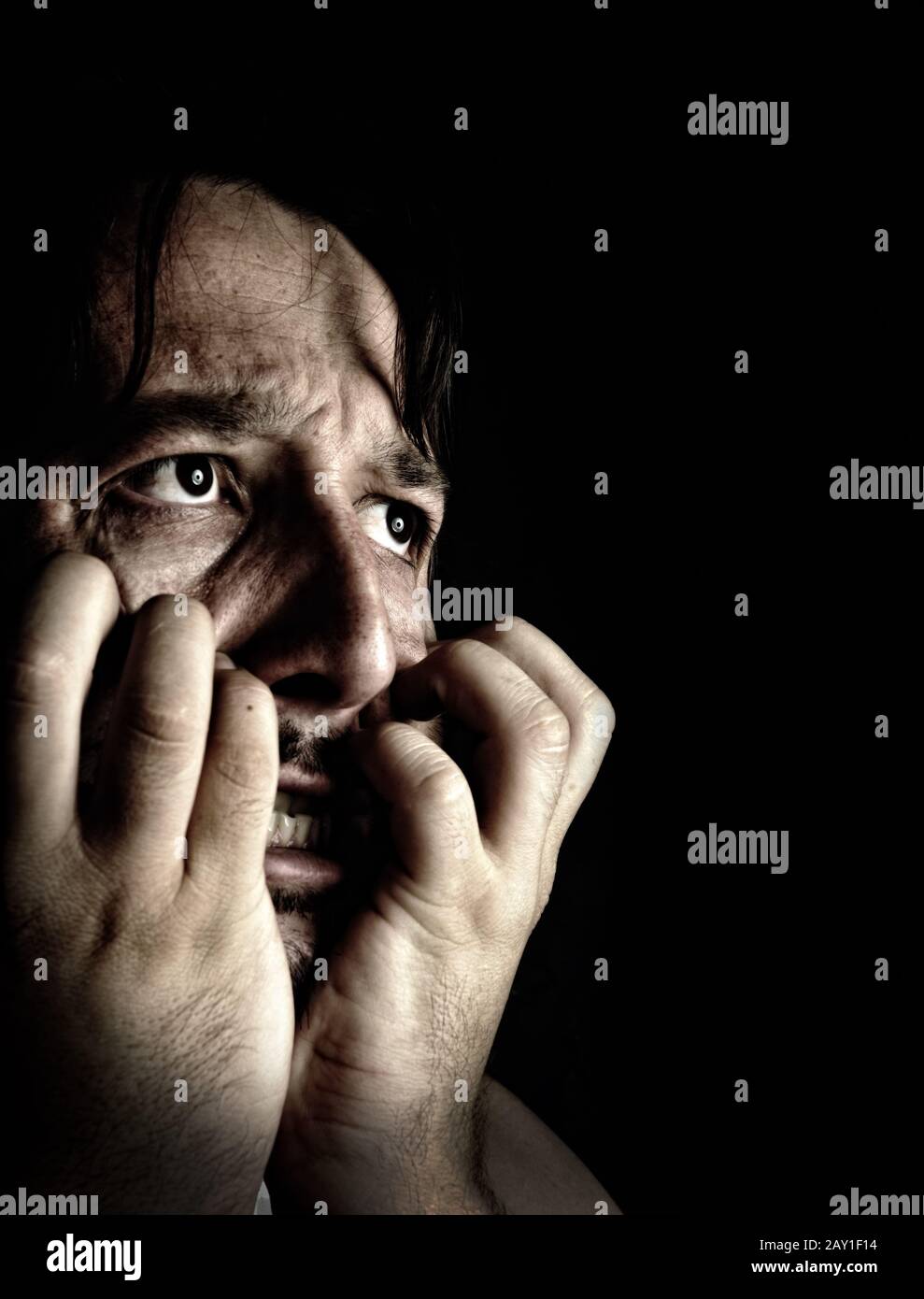 Desperate furious and angry man in dark, low key light, added grain for ...