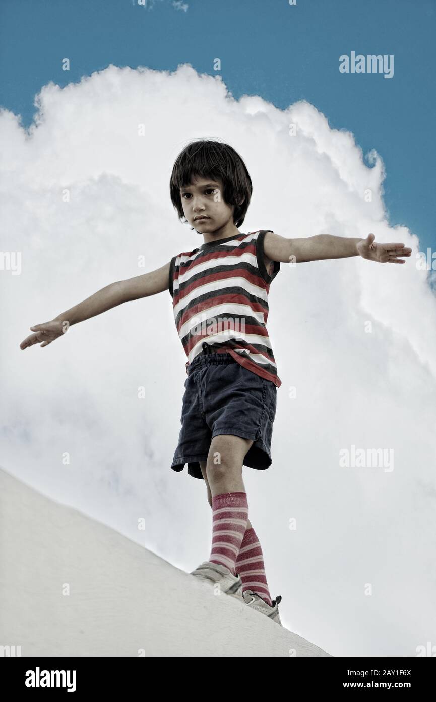 Kid walking and balancing on wall Stock Photo - Alamy