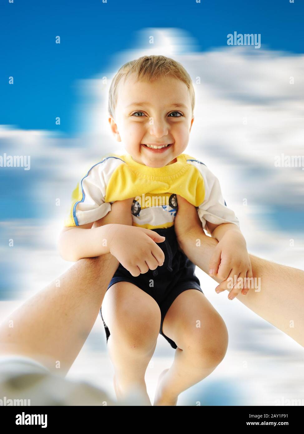 Very happy little cute boy up in his father's arms, rotating together ...