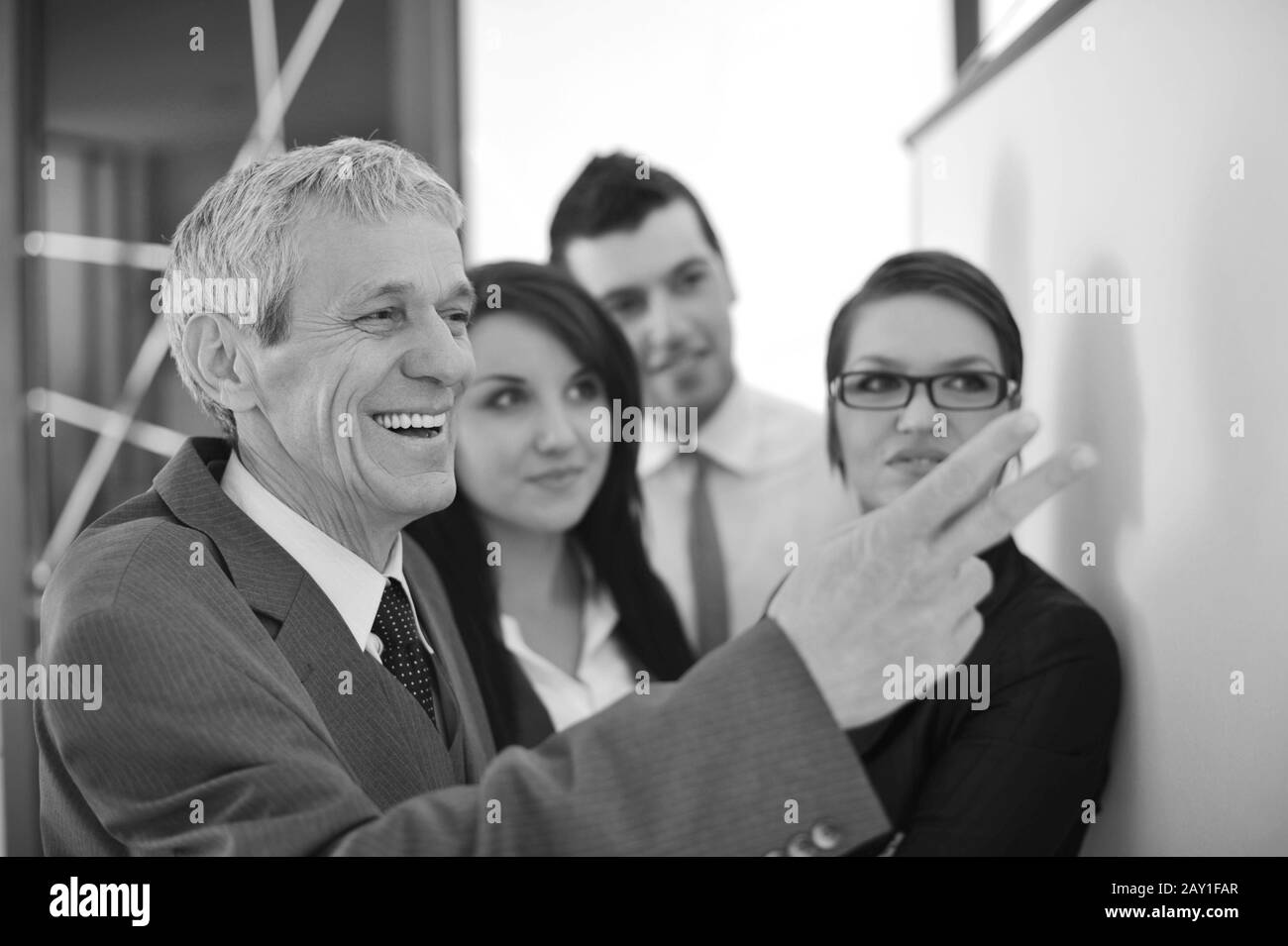Businessman board explaining female colleague Black and White Stock ...