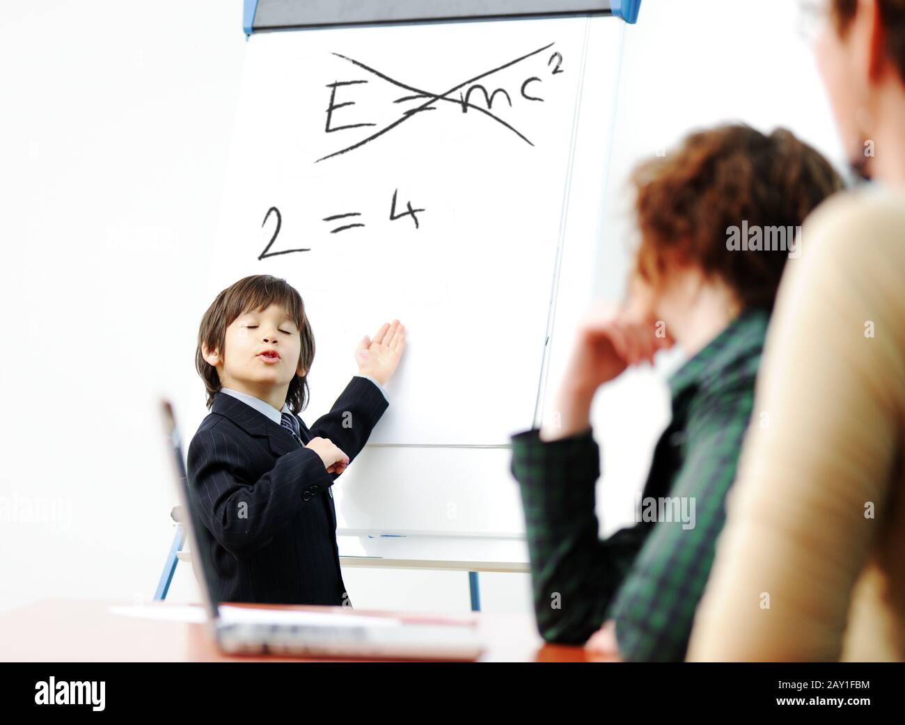 Genius kid on business presentation speaking to adults and giving them ...