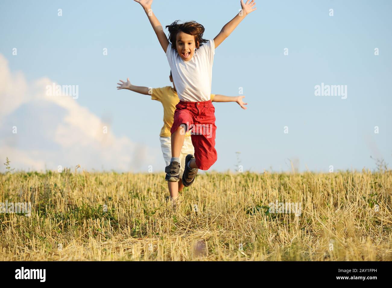 Two kids on meadow Stock Photo - Alamy