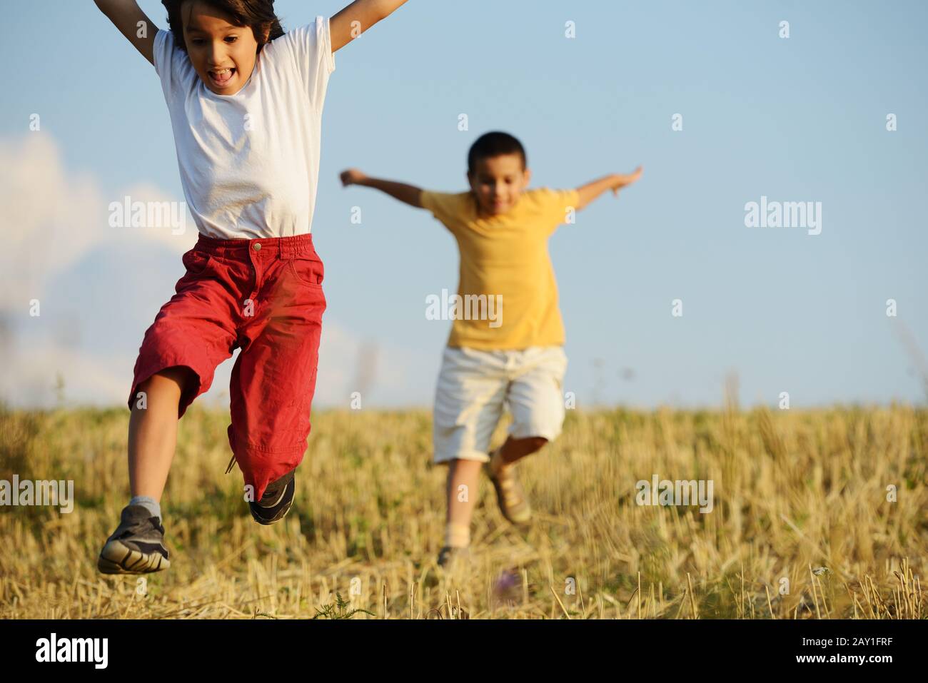 Two kids on meadow Stock Photo - Alamy