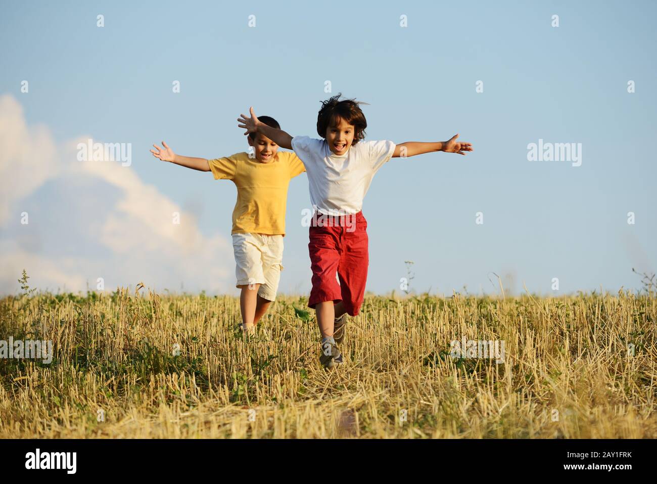 Two kids on meadow Stock Photo - Alamy