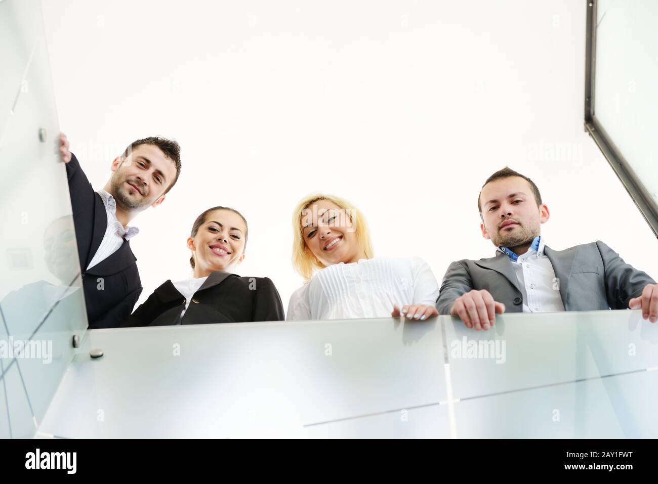Successful business people on railing Stock Photo - Alamy