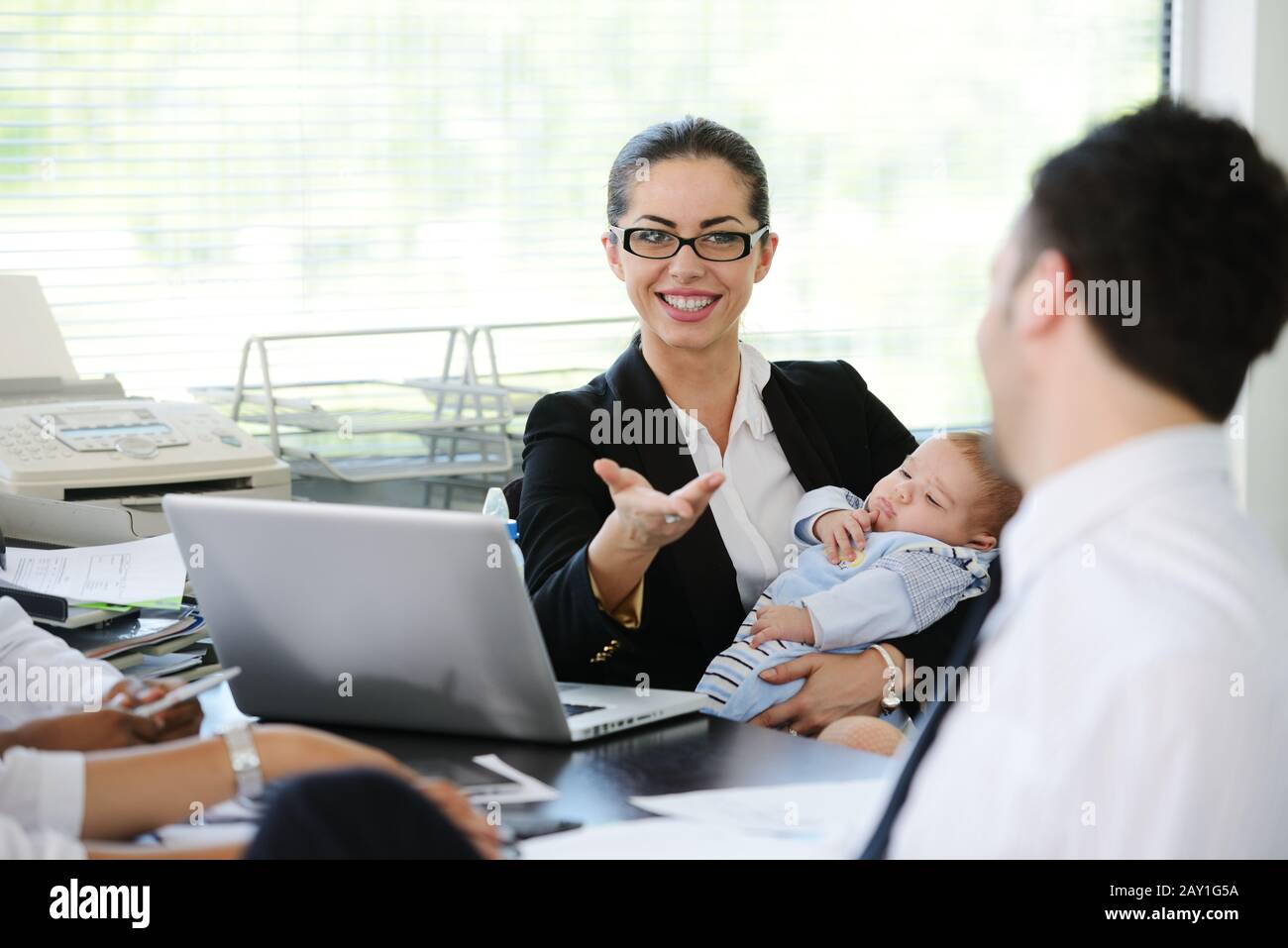 Business people taking care of baby in office Stock Photo - Alamy