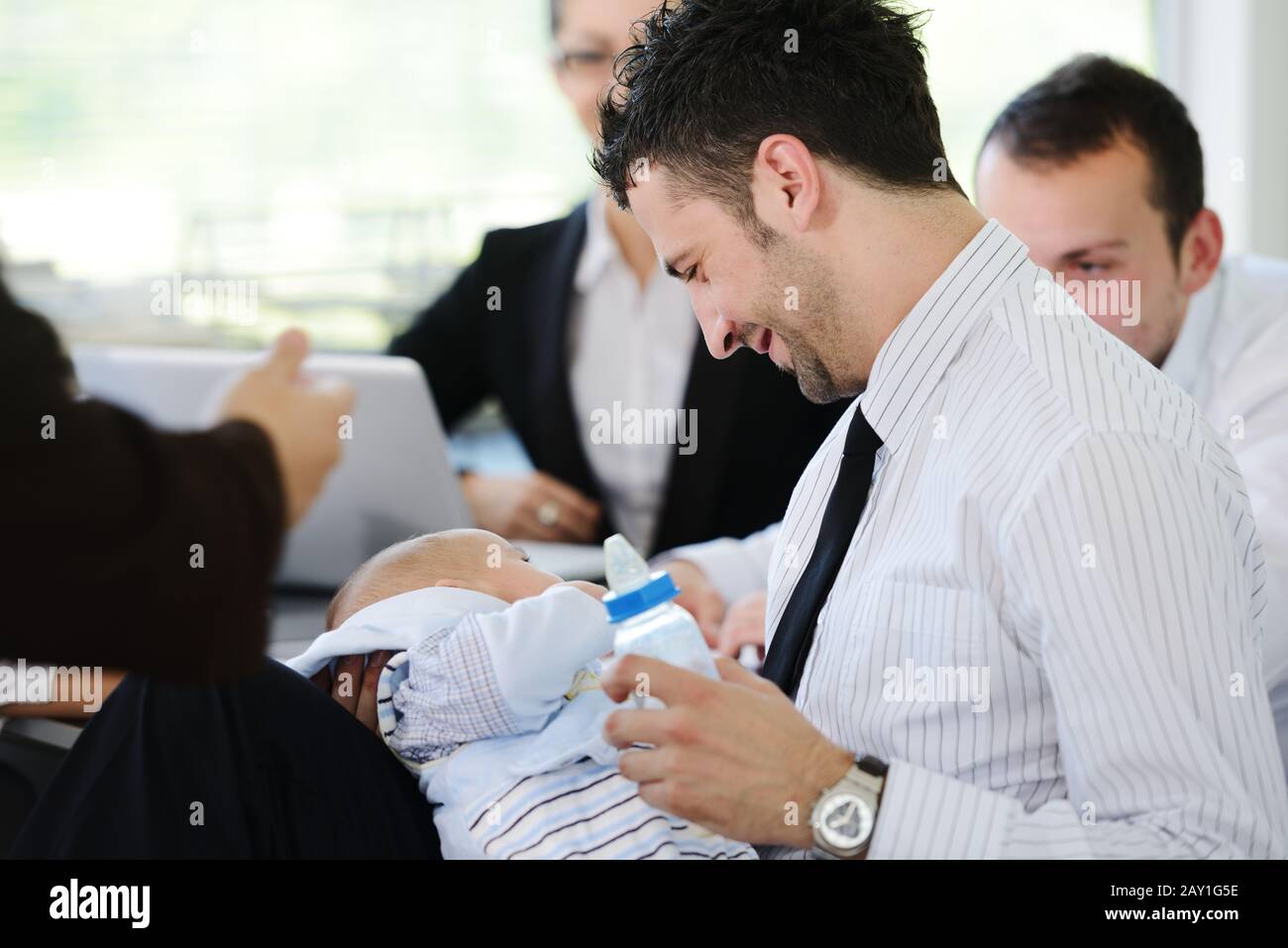 Business people taking care of baby in office Stock Photo - Alamy