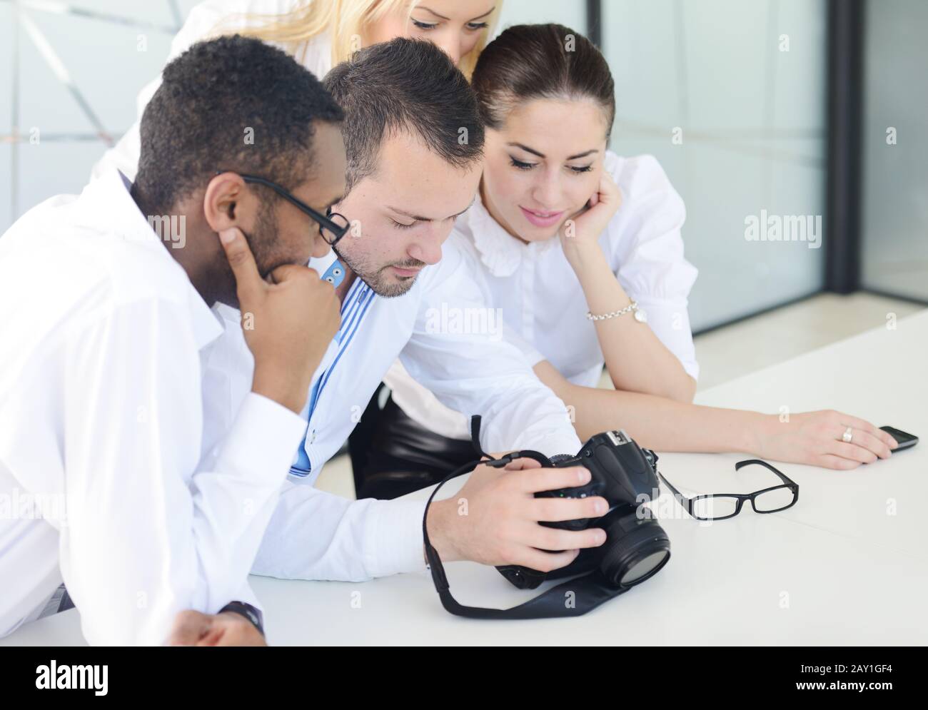 Successful business people looking at display of digital camera Stock ...
