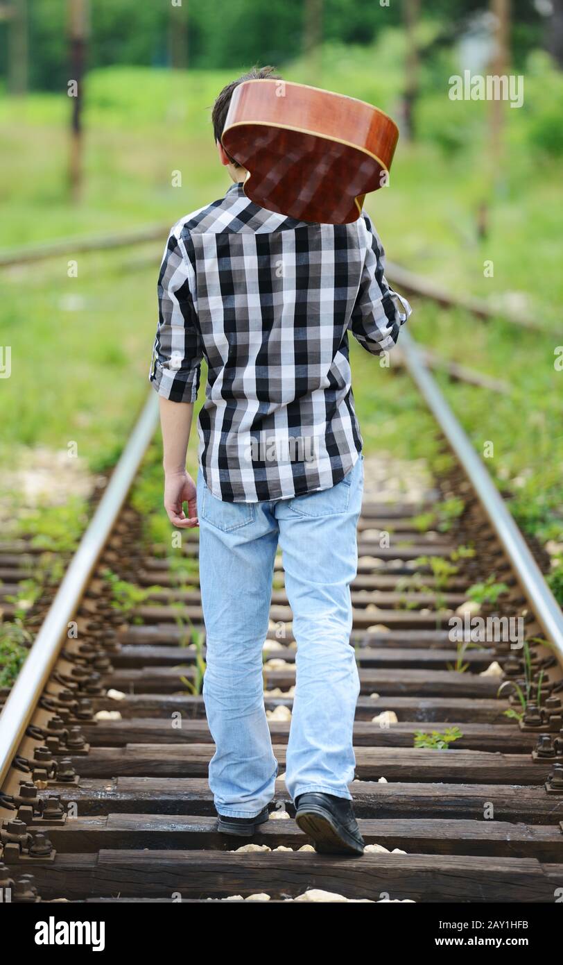 Guy having guitar on his back Stock Photo - Alamy