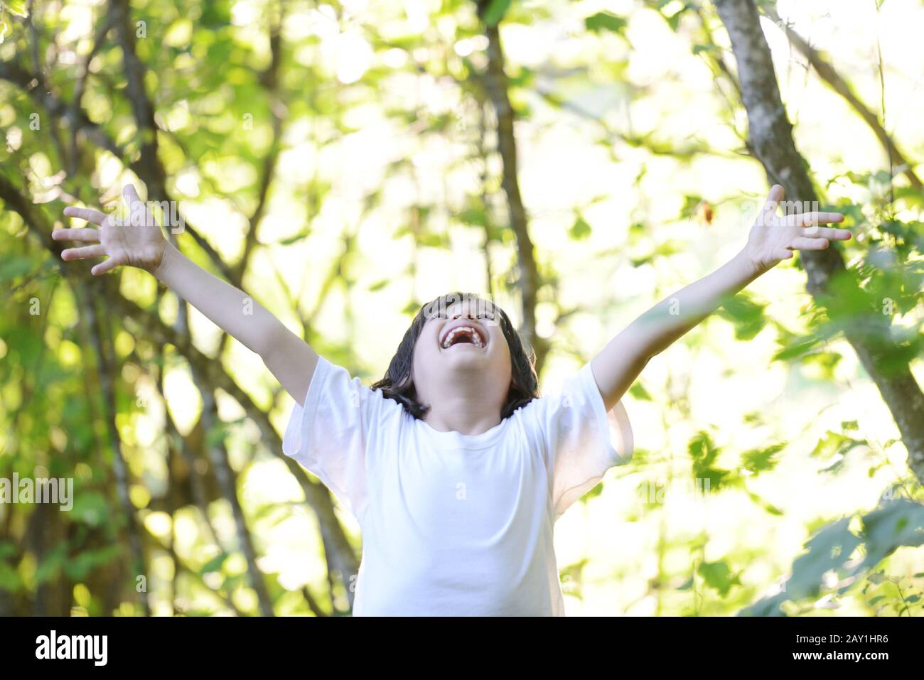 Enjoying the nature. Cute little boy with arms raised enjoying the ...