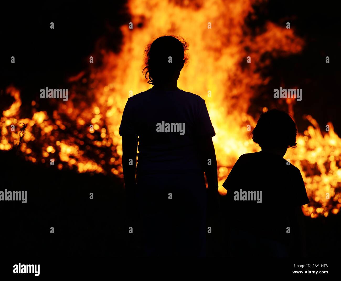 Two children looking at big fire Stock Photo - Alamy