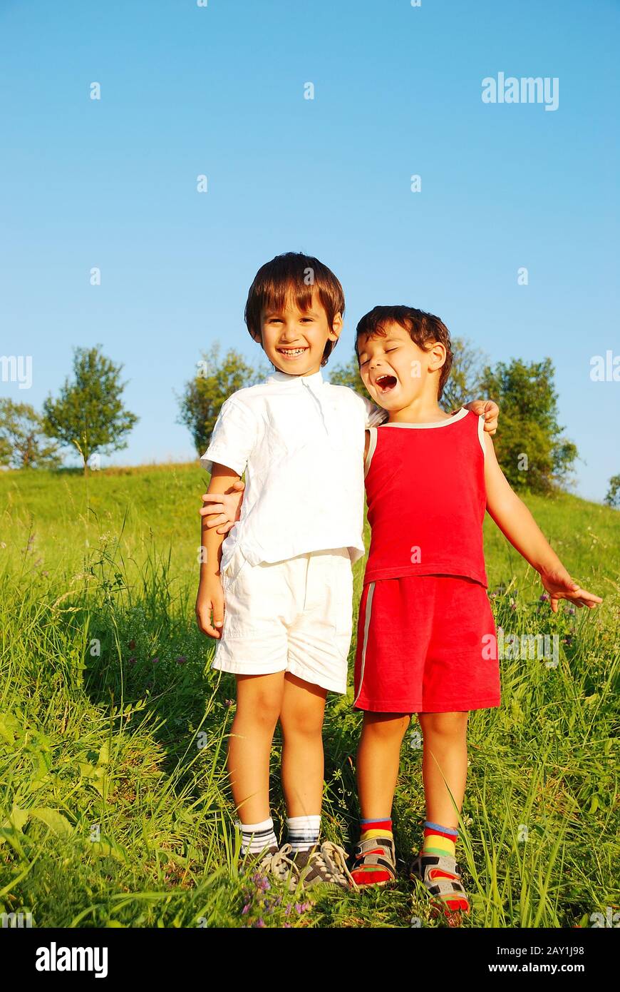 Little cute children on beautiful green field Stock Photo - Alamy