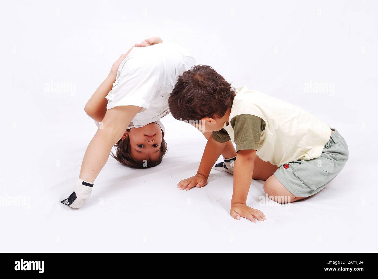 Two cute kids playing together isolated in white Stock Photo - Alamy