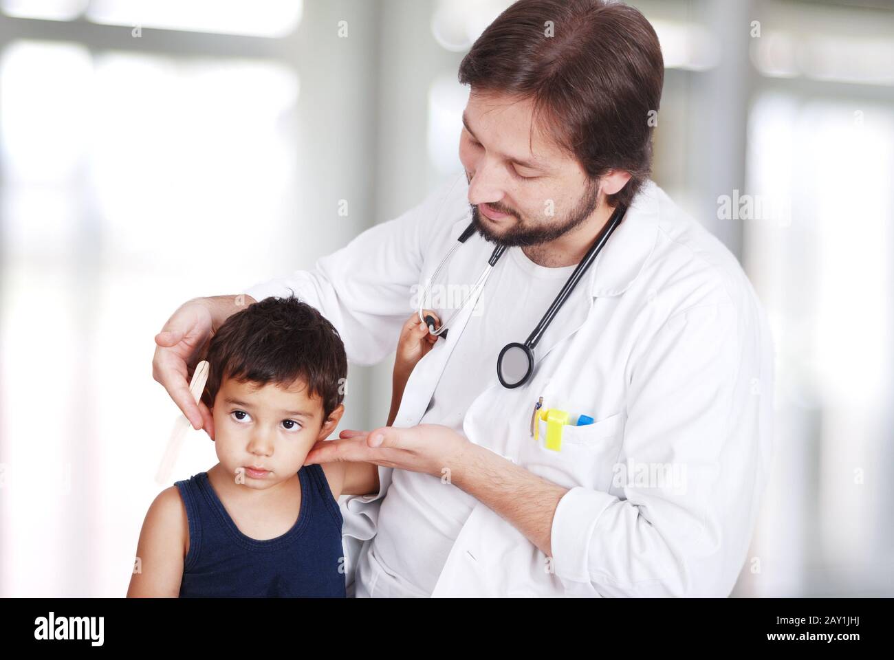 Young doctor examining little boy in hospital Stock Photo - Alamy