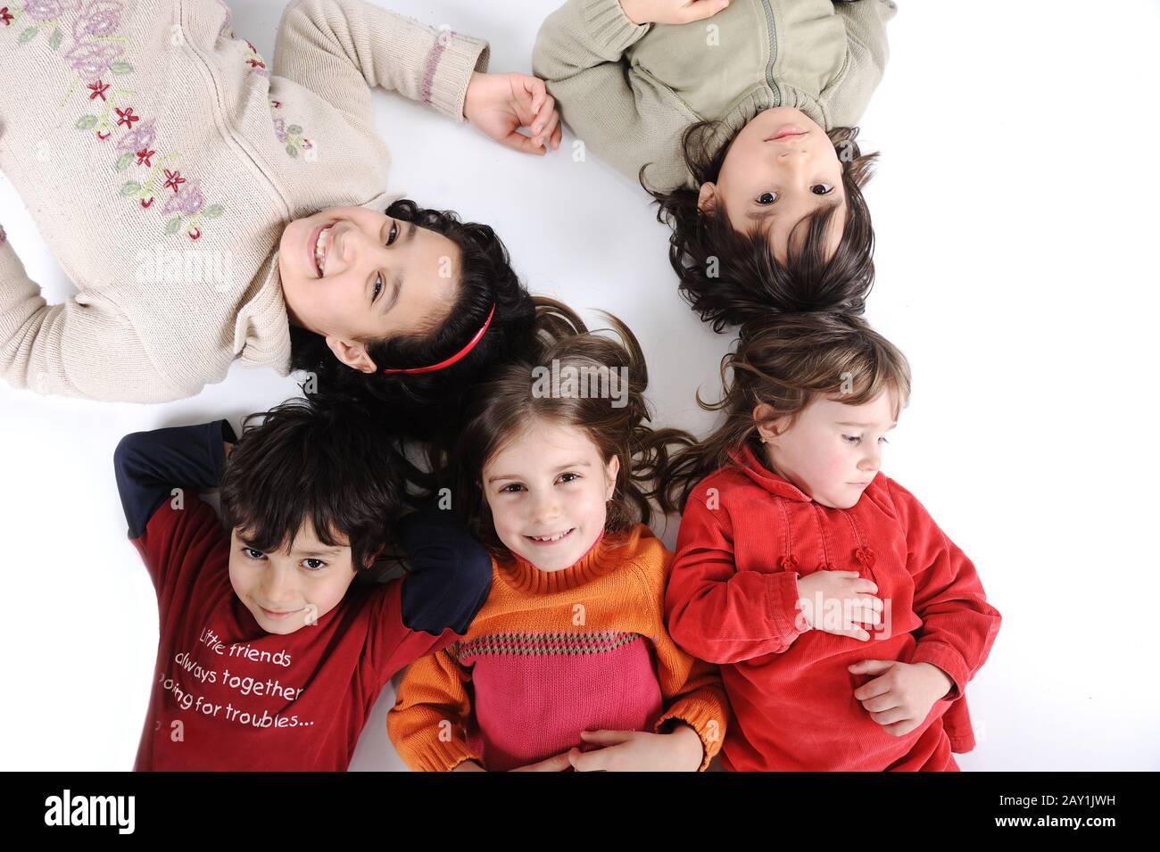 Children group in circle laying on ground Stock Photo - Alamy