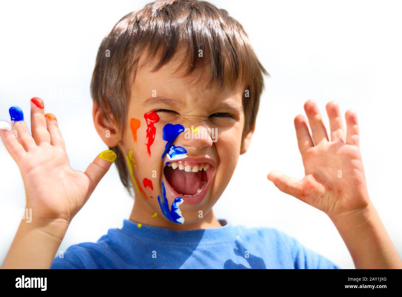 Kid with color on his fingers and face looking Stock Photo - Alamy