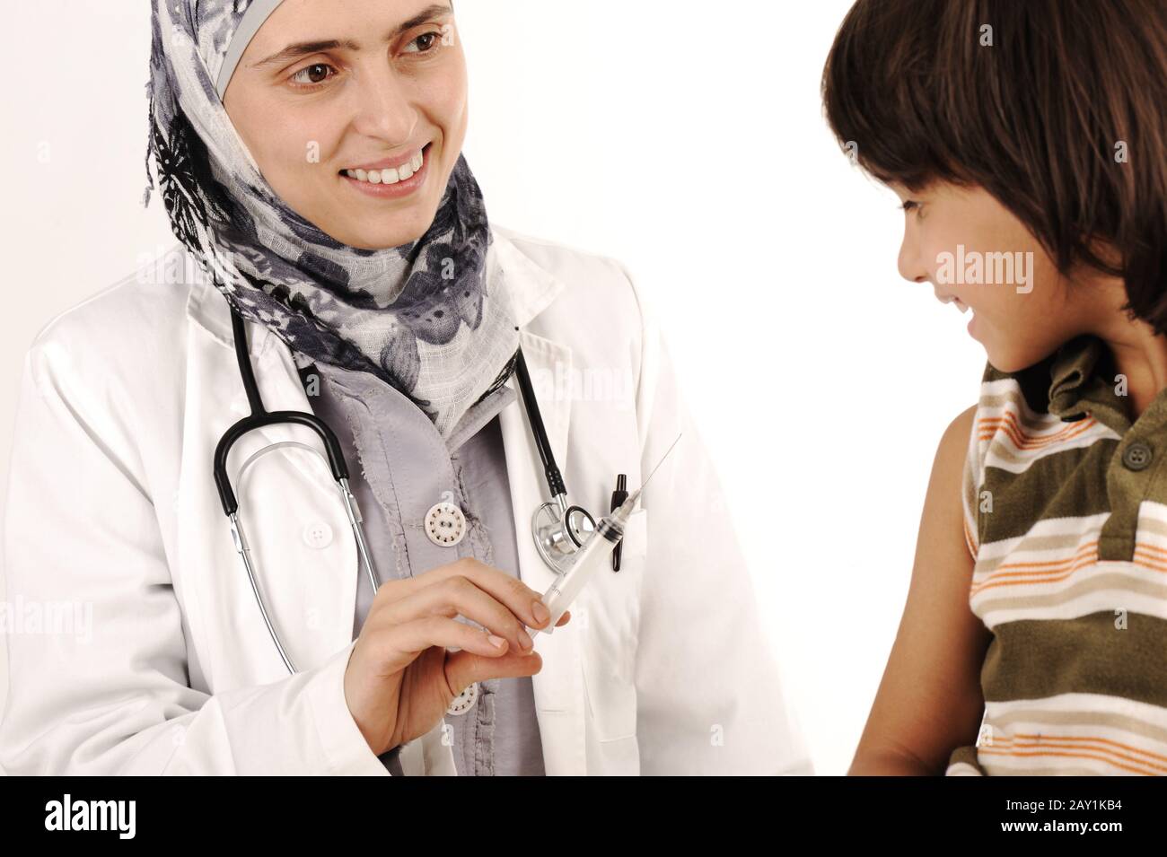 Muslim female doctor in hospital giving an injection to a little boy ...