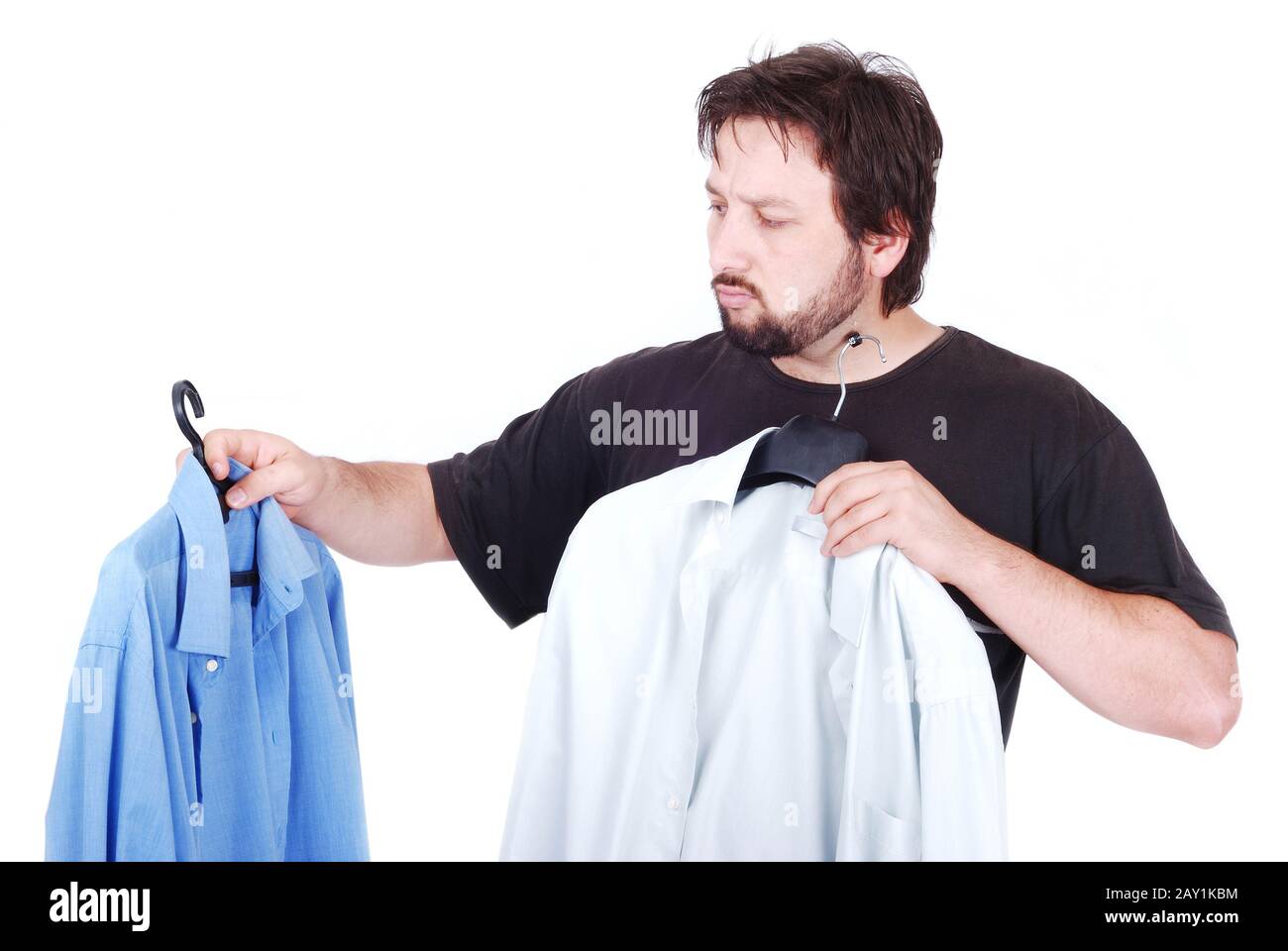 Man choosing between two shirts Stock Photo - Alamy