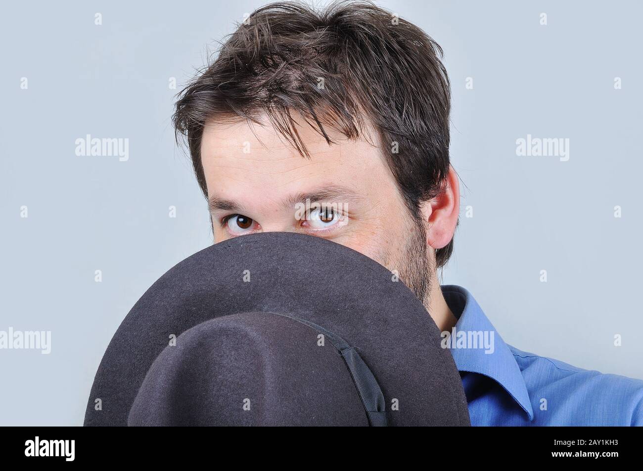 Young attractive man with blue shirt and the hat Stock Photo - Alamy