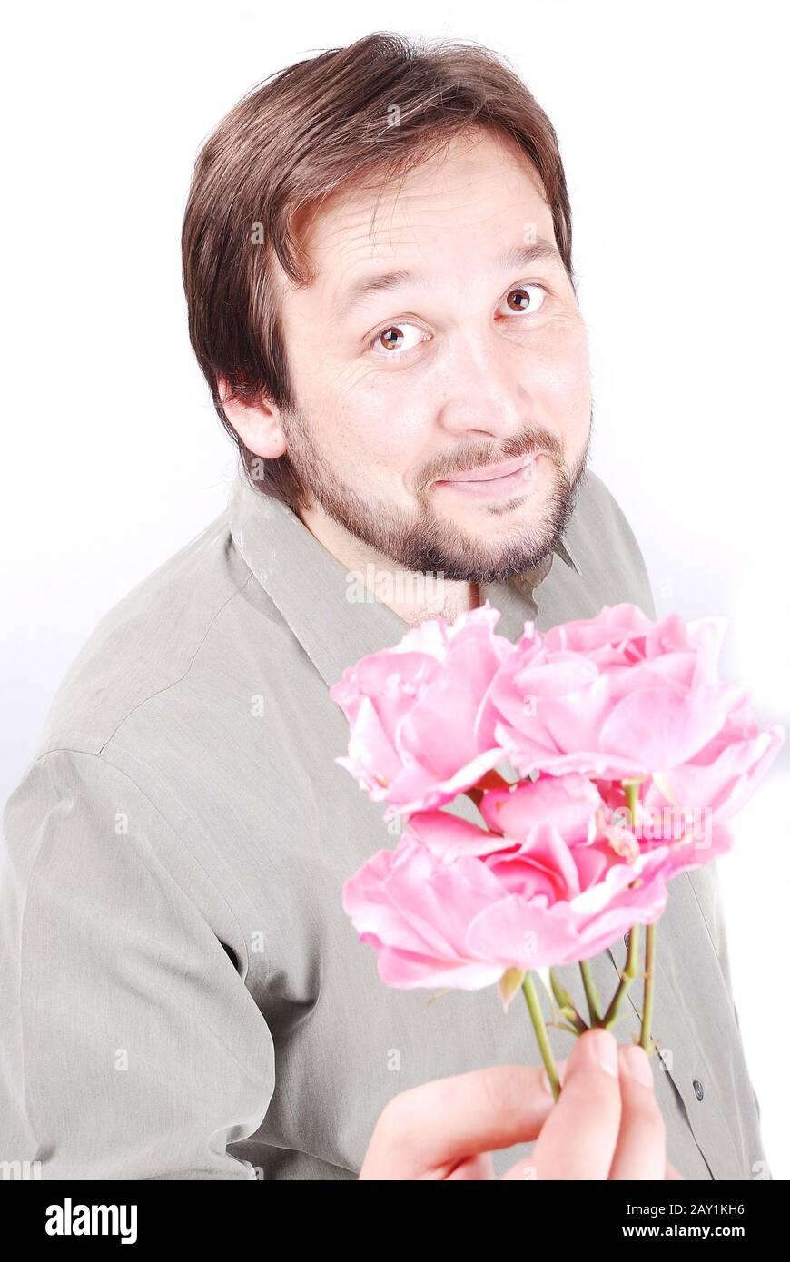 Cute man offering pink roses and smiling Stock Photo - Alamy