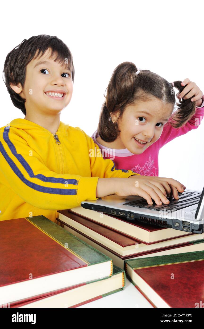 Children playing on laptop put on books Stock Photo - Alamy
