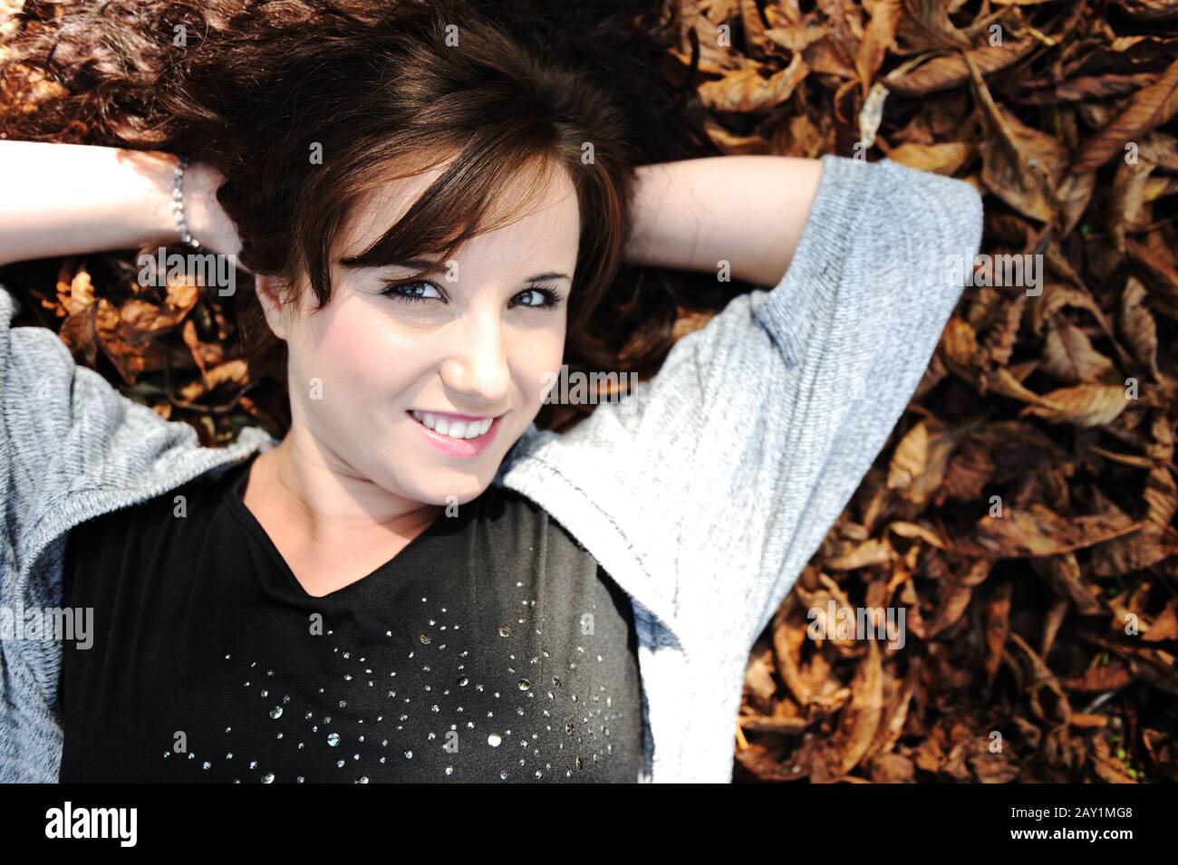 Young beauty girl laying on autumn ground and leaves, perfect face and ...