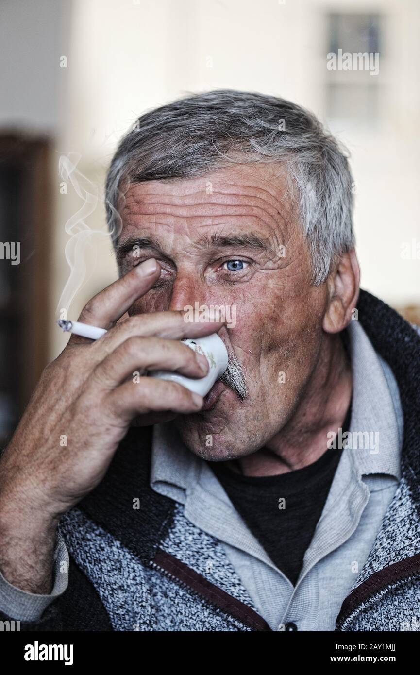 Old man with mustache smoking cigarette and drinking coffee Stock Photo ...