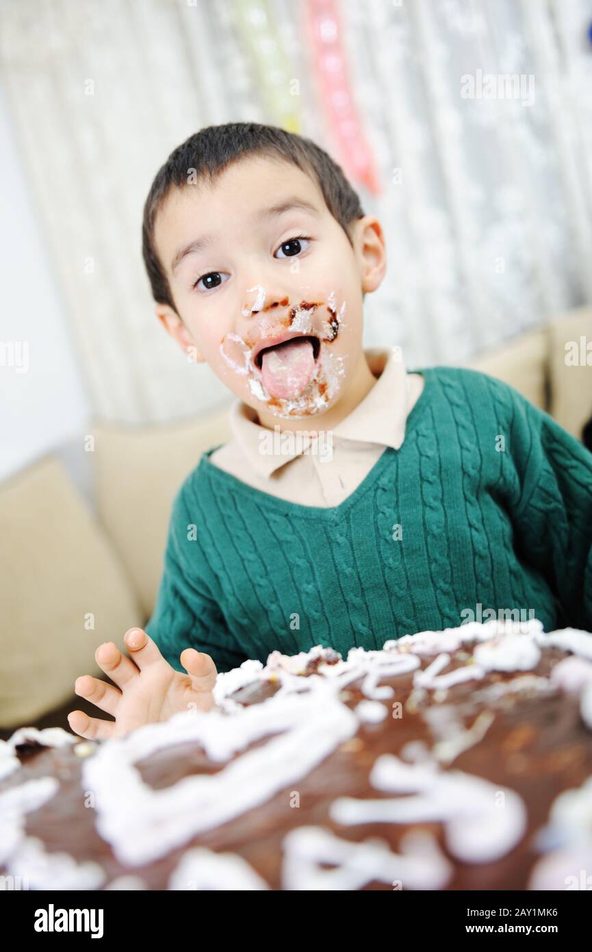 Messy cute kid with birthday cake Stock Photo - Alamy