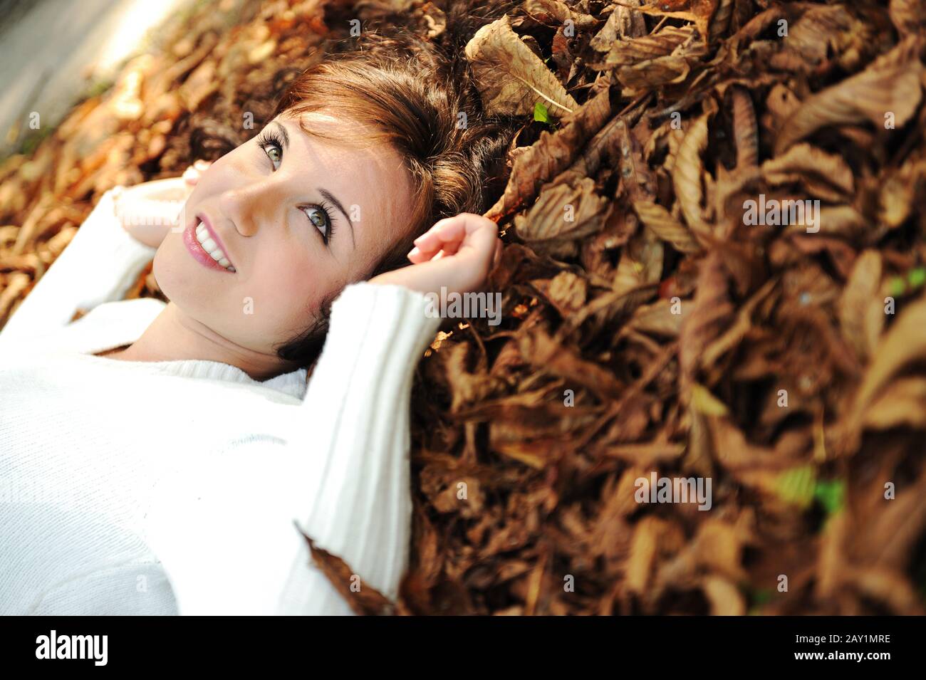 Young beauty girl laying on autumn ground and leaves, perfect face and ...