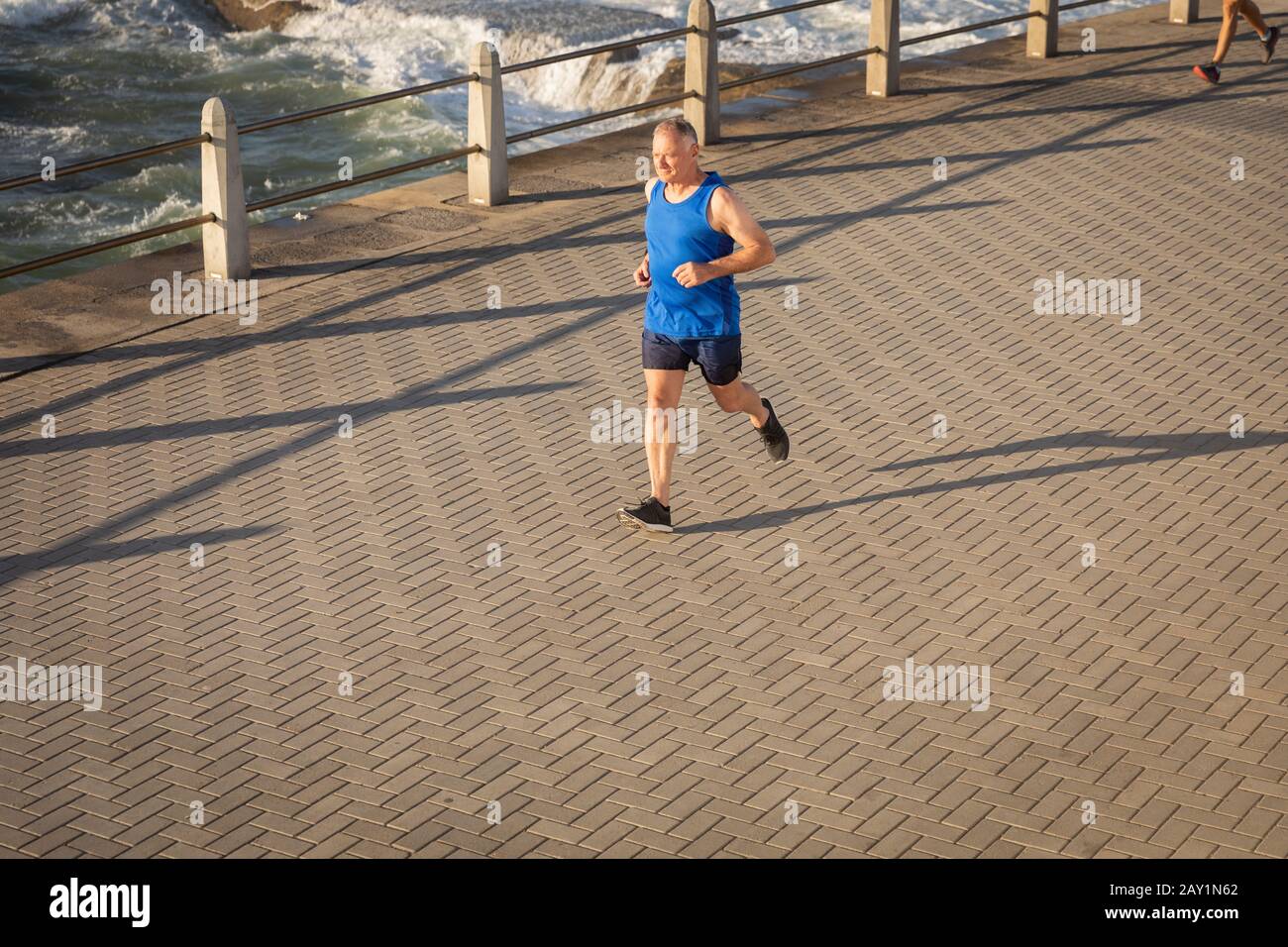 Jogger running on seaside Stock Photo - Alamy
