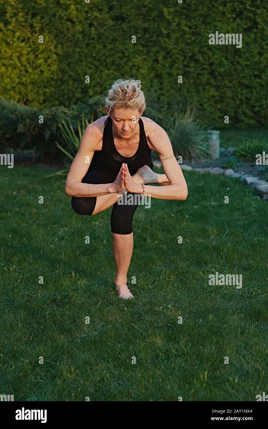woman doing lotus yoga position outside in the garden Stock Photo - Alamy