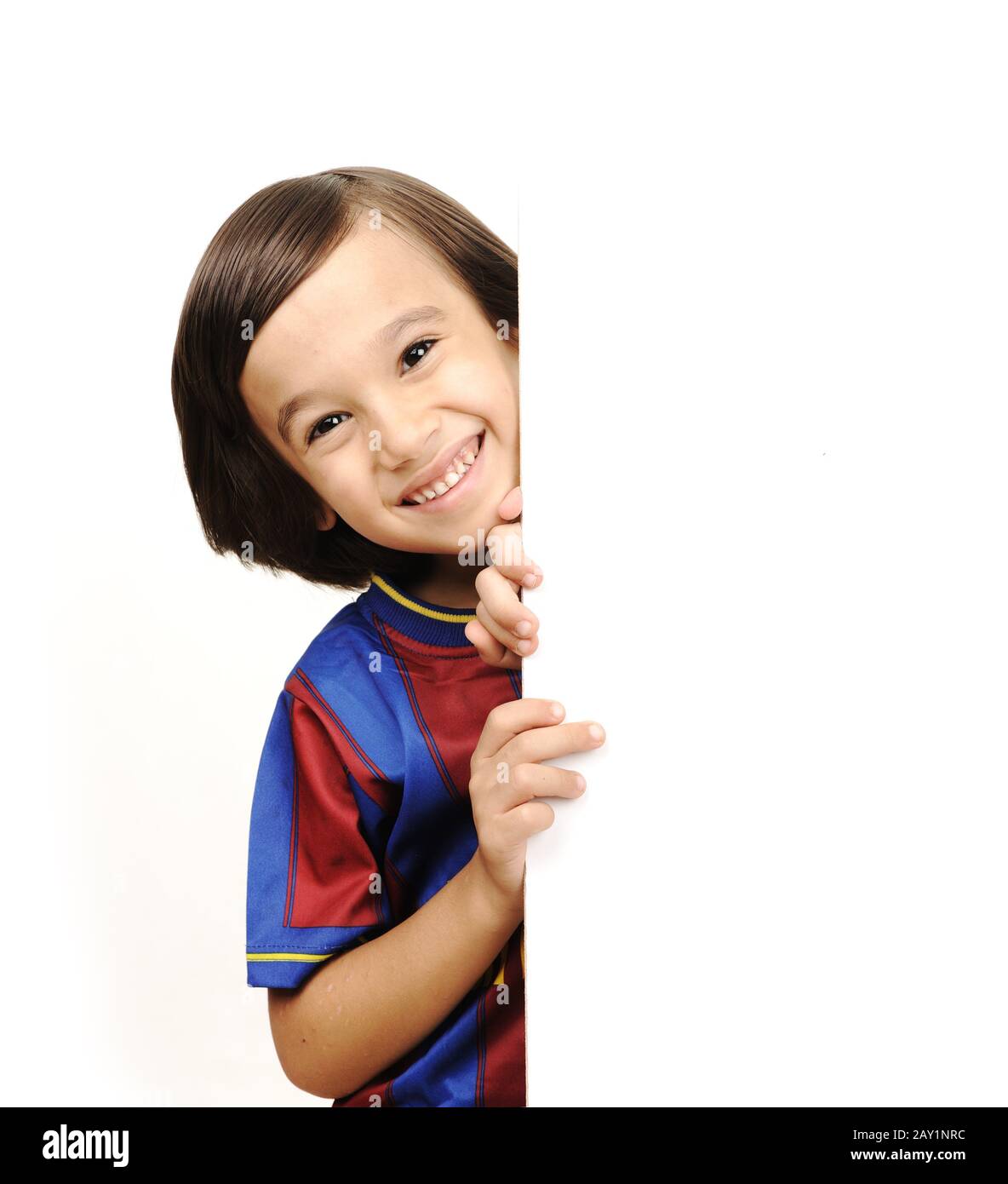 young happy smiling little boy look outs from the blank billboard ...