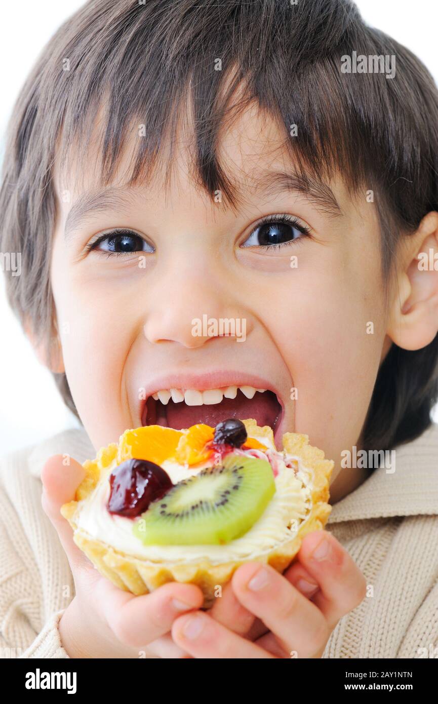 Cute little kid trying out delicous cake Stock Photo - Alamy