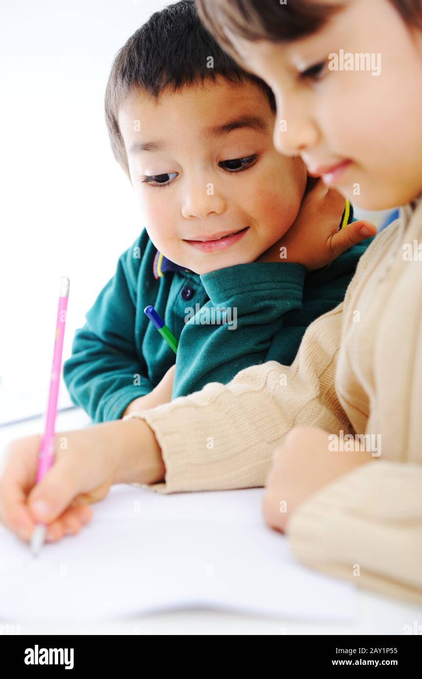 Two cute school boys working on their homework together Stock Photo - Alamy