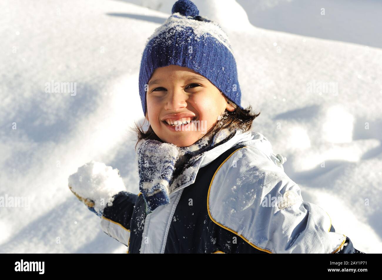Happy smiling boy throwing snow to you Stock Photo - Alamy