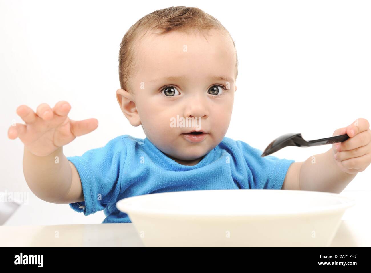Cute adorable one year old baby with green eyes eating on table Stock ...
