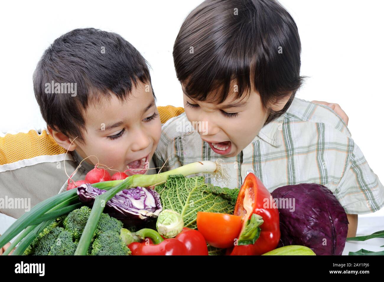 Two little boys eating vegetables Stock Photo - Alamy