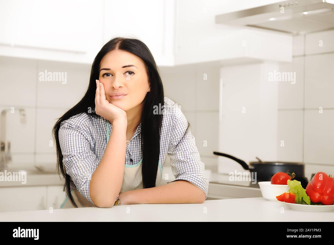 Beautiful woman thinking in kitchen Stock Photo - Alamy